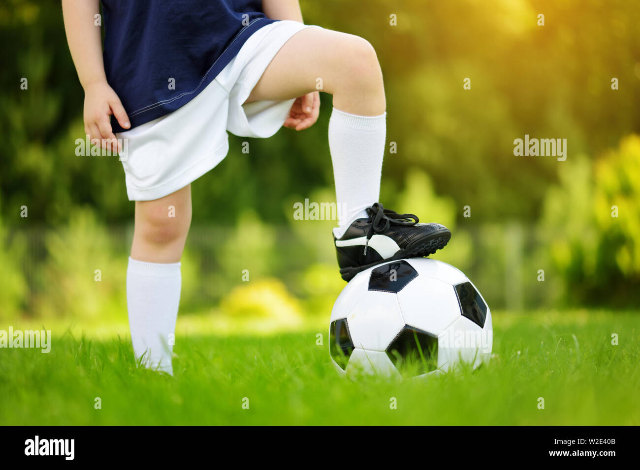 Close-up of a child having fun playing a soccer game on sunny summer ...