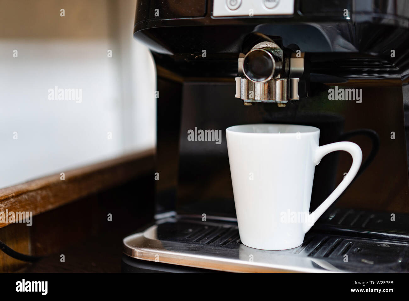 White Coffee cup standby on the professional coffee machine ready to ...