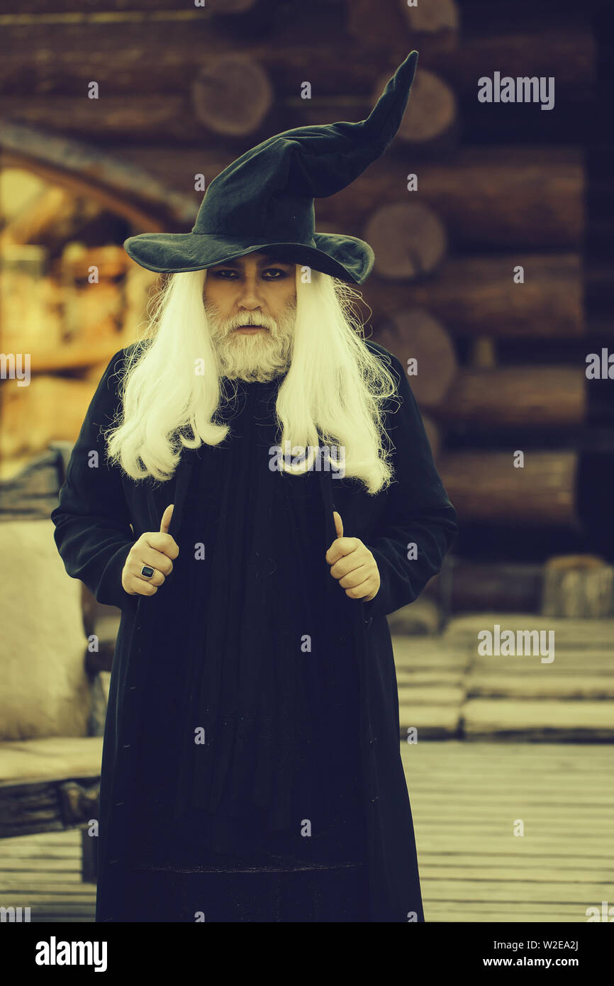 Old man wizard with long grey hair beard in black costume and hat for ...