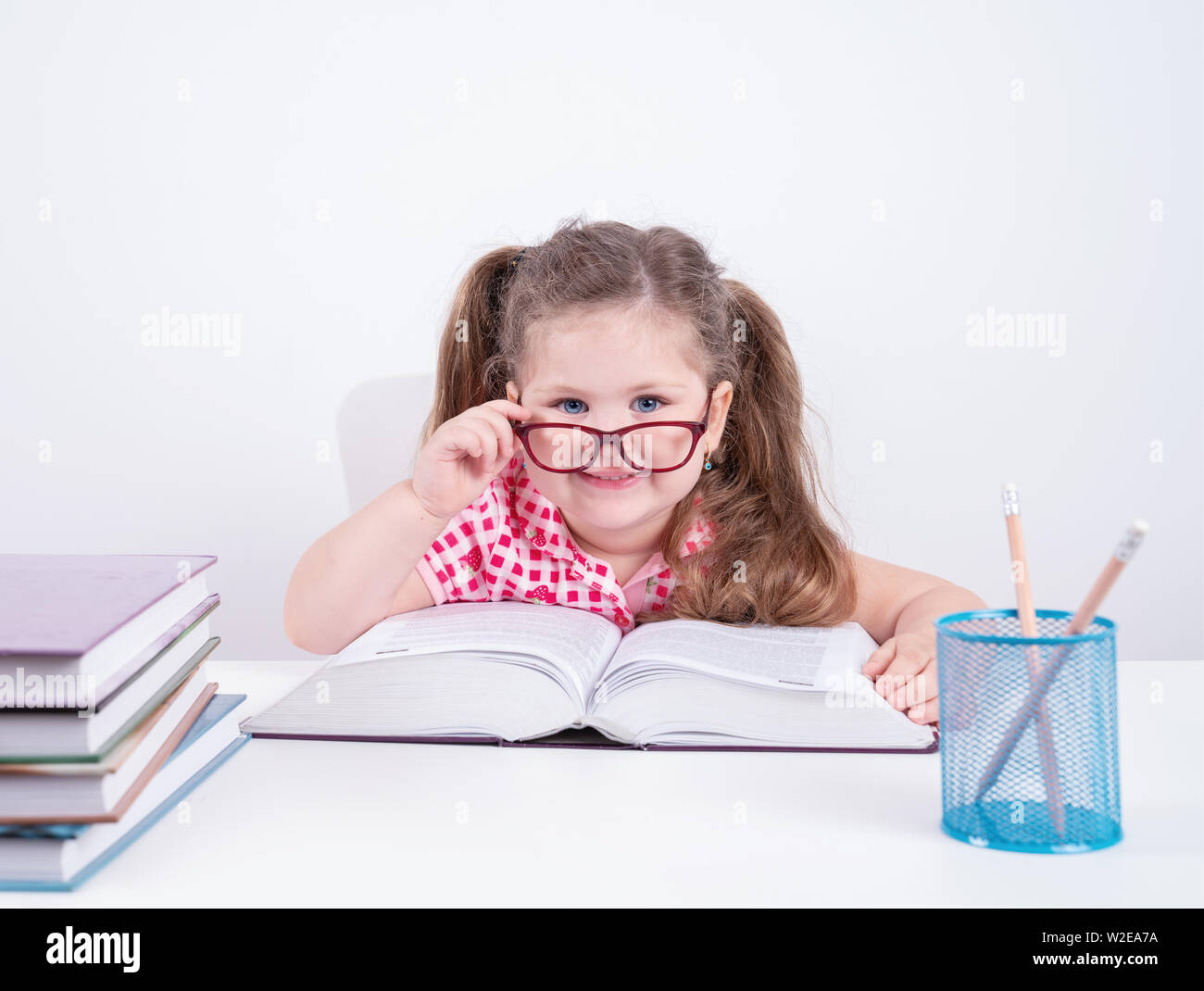smiling blond little cute girl studying on books Stock Photo - Alamy