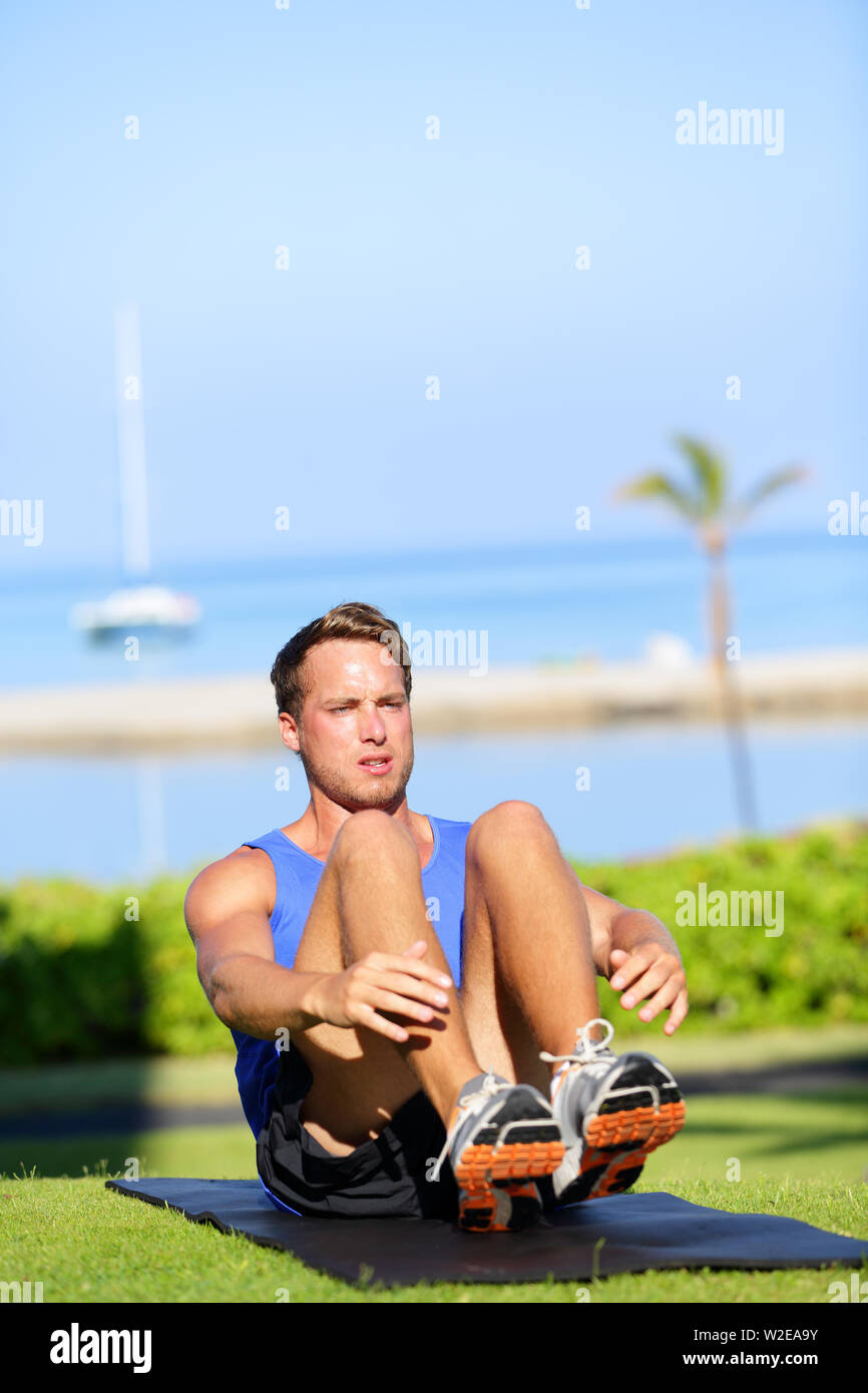 Training fitness man doing sit-ups exercise for abs outdoors. Fit male ...