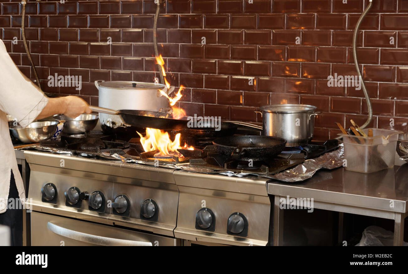 Chef is making flambe dish in restaurant kitchen Stock Photo - Alamy