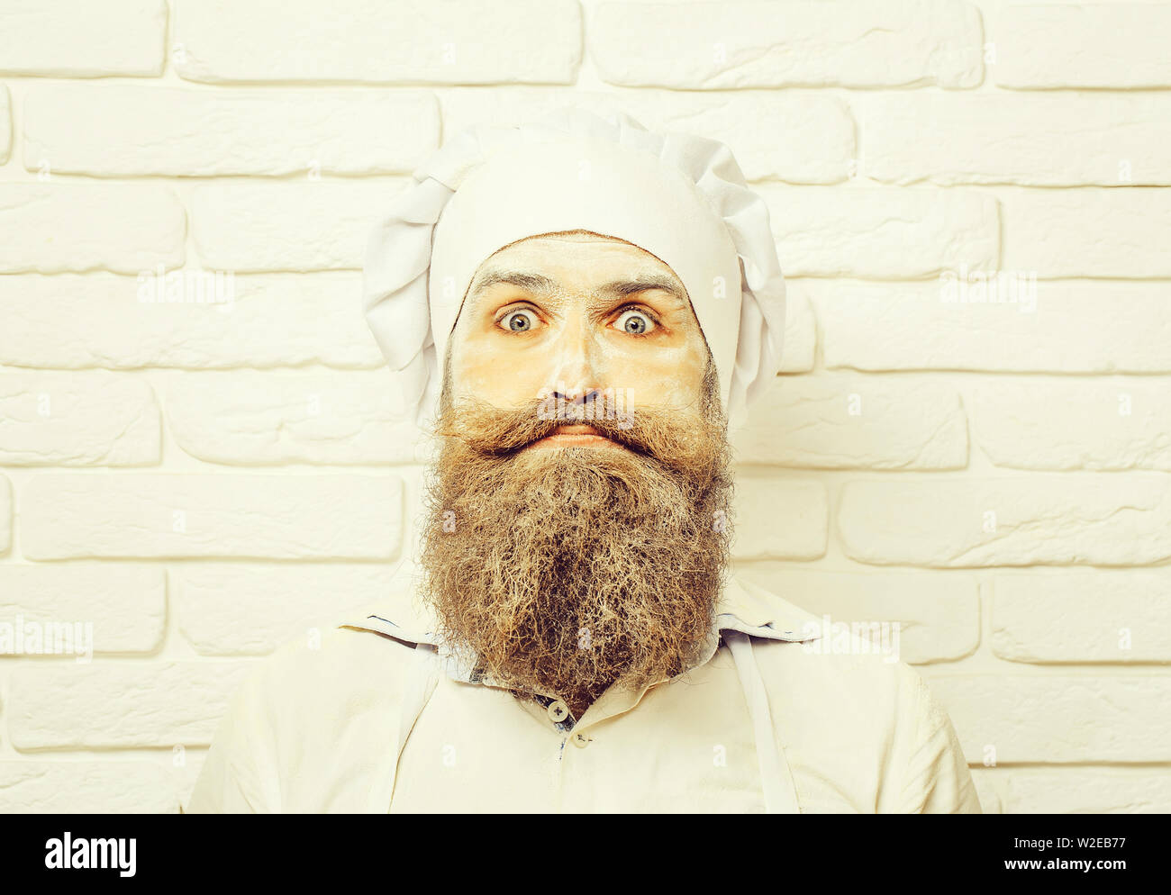 Handsome crazy man, cook or baker with flour on face, beard and ...