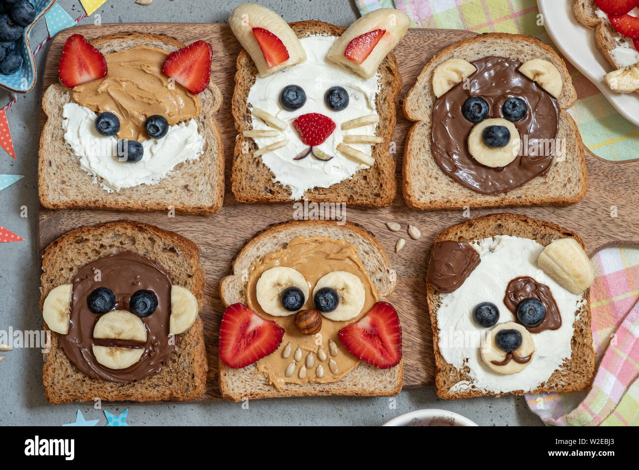 Animal faces toasts with spreads, banana, strawberry and blueberry ...