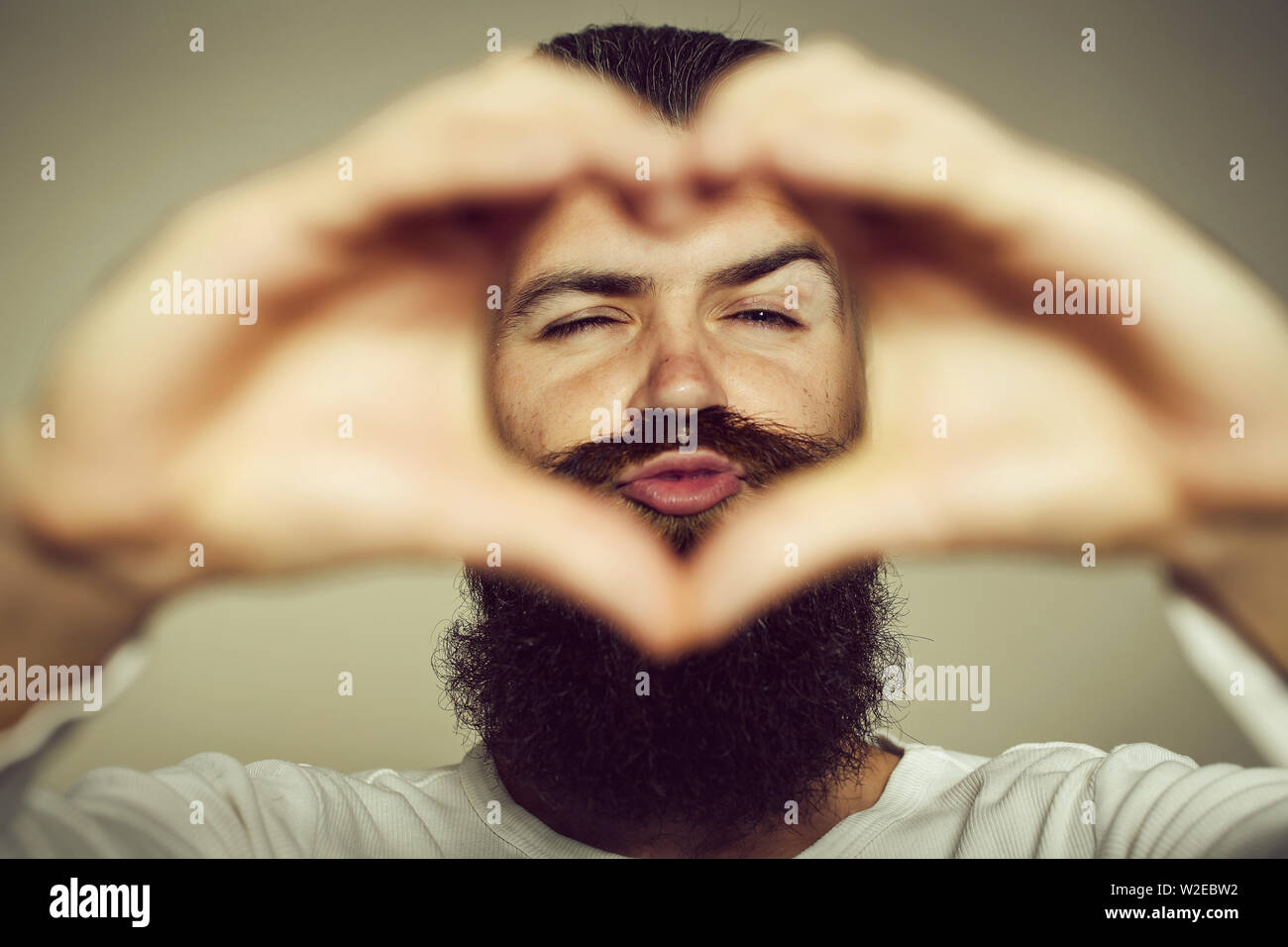 handsome young man with long beard and moustache on face holding hands ...