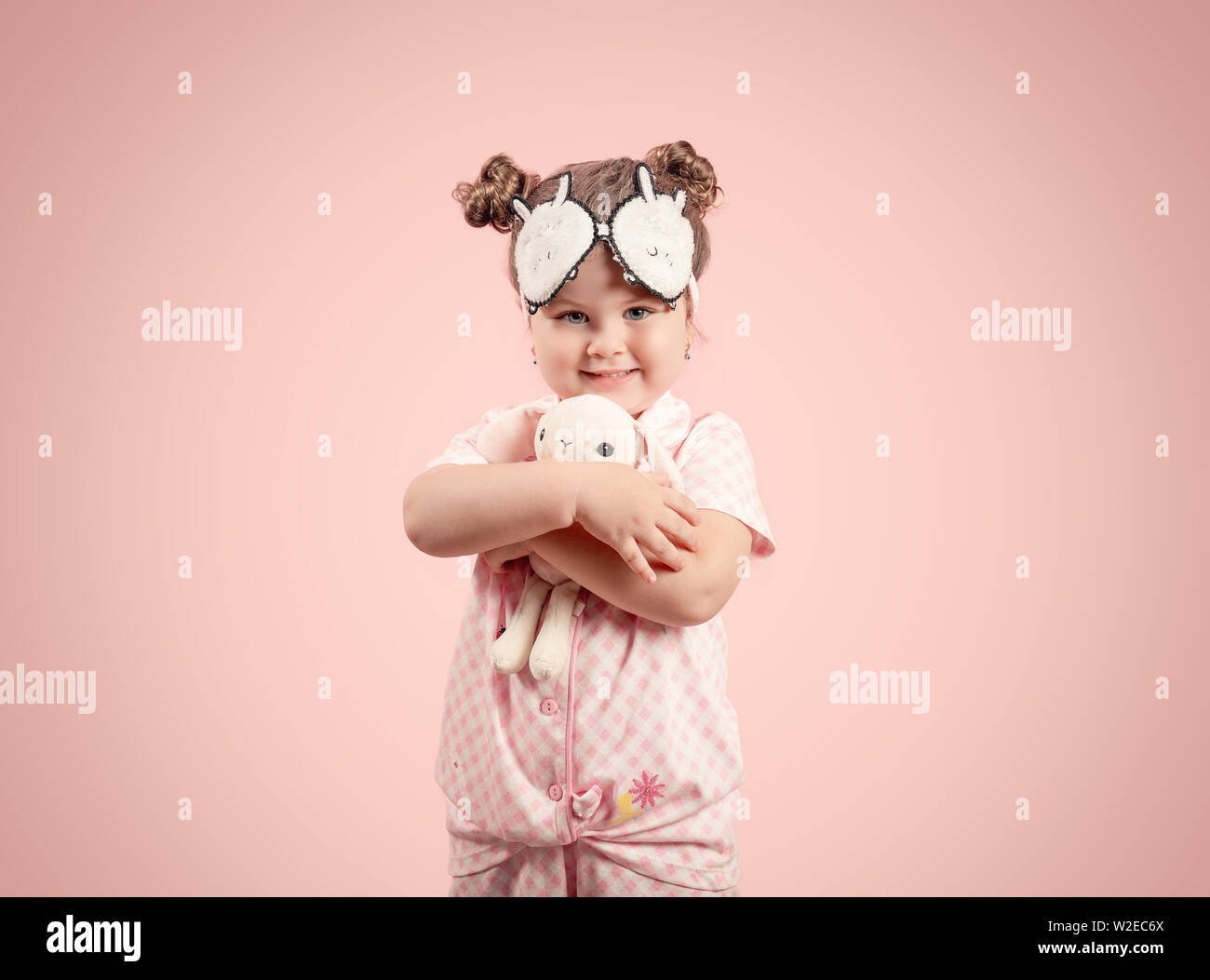 Smiling little child hugging with a toy on pink background Stock Photo ...