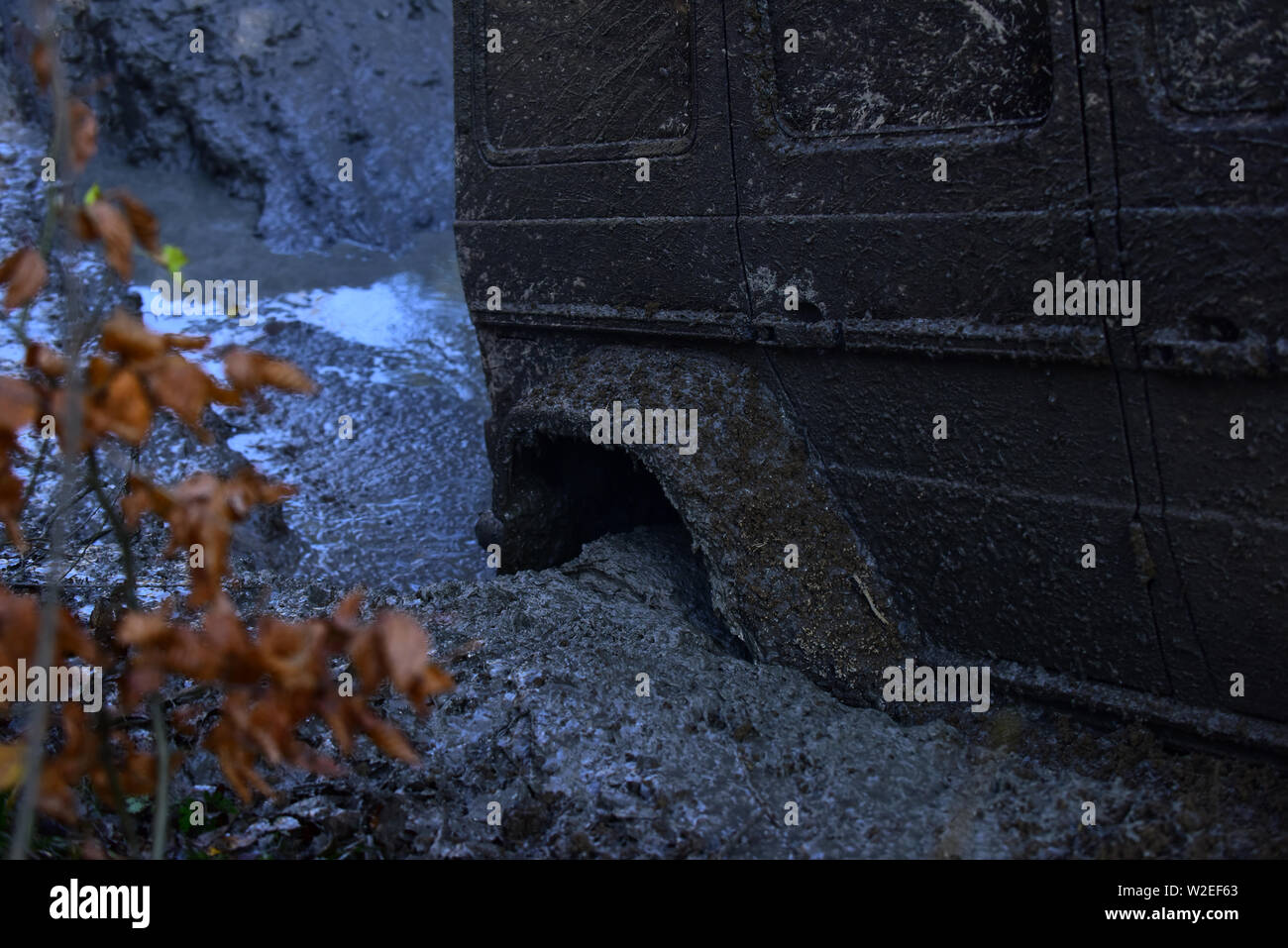 Wheel in deep puddle of mud. Dangerous expedition concept. Offroad tire ...