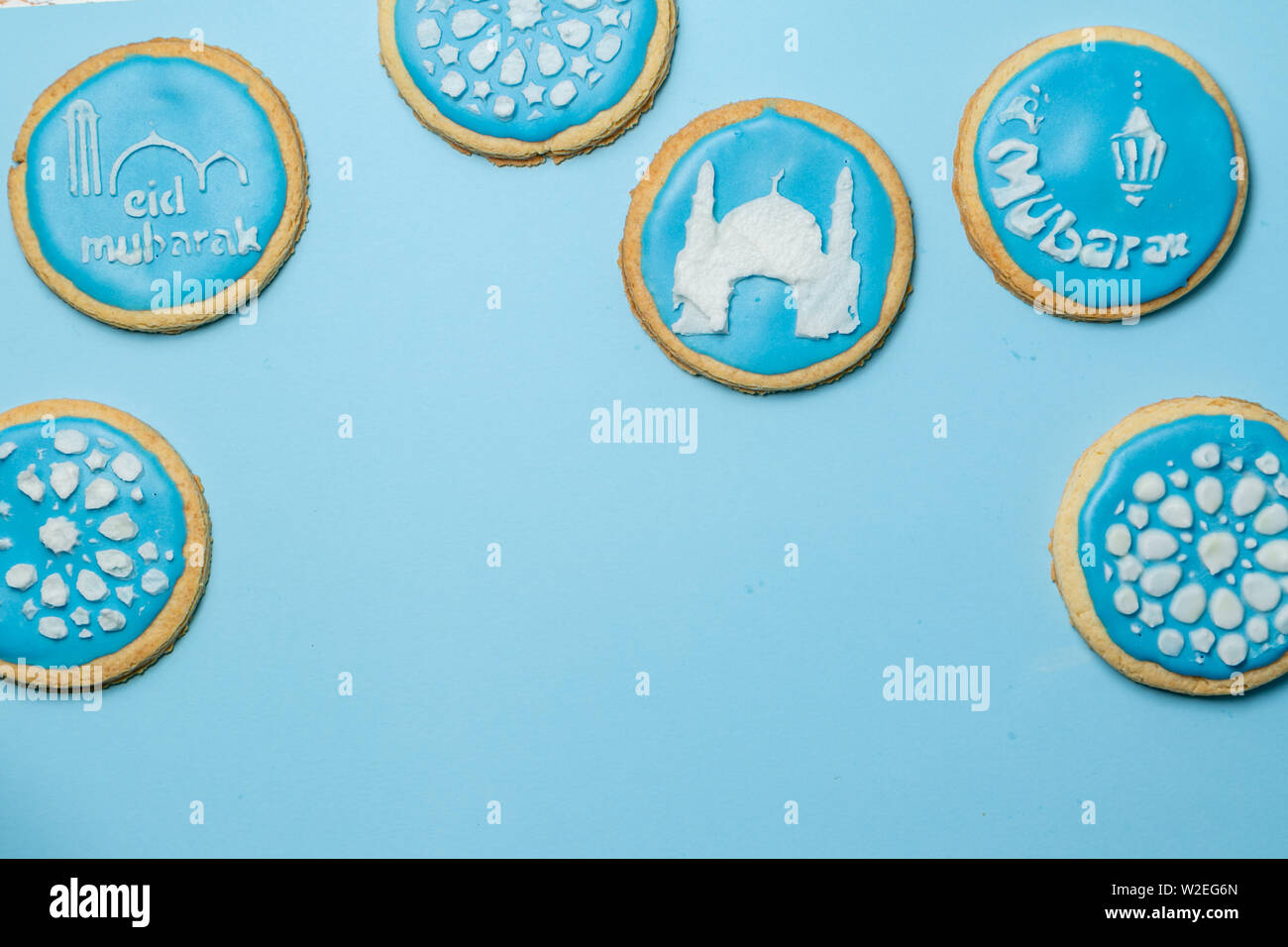 Eid Al-Adha Mubarak holiday concept - blue cookies with stenciled ...