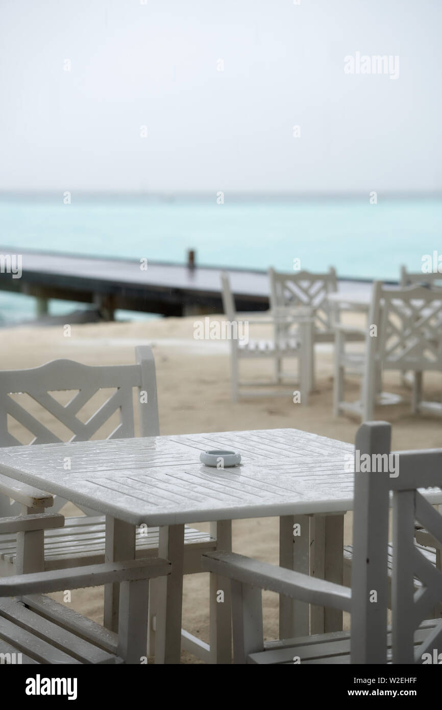 White table restaurant on the beach. The rainy season has begun Stock ...