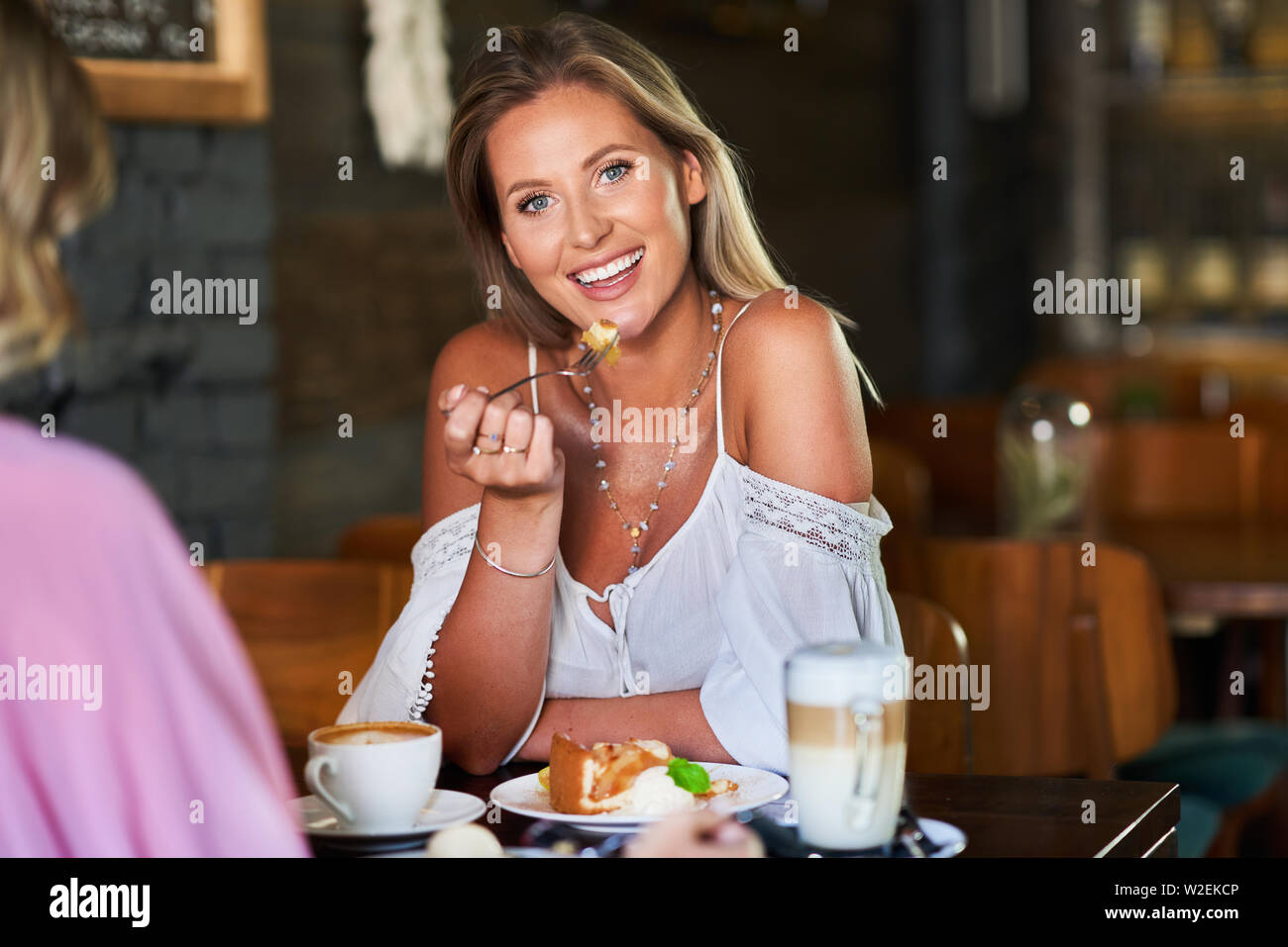 Two girl friends eating lunch in restaurant Stock Photo - Alamy