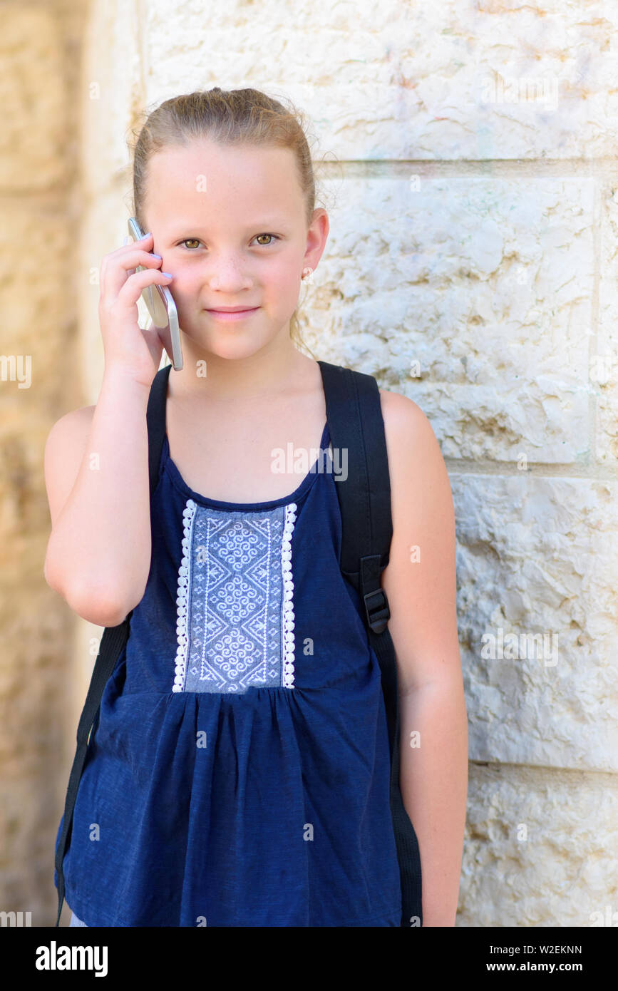 Outdoor portrait of happy girl 8-9 year old talking on phone. Cute ...
