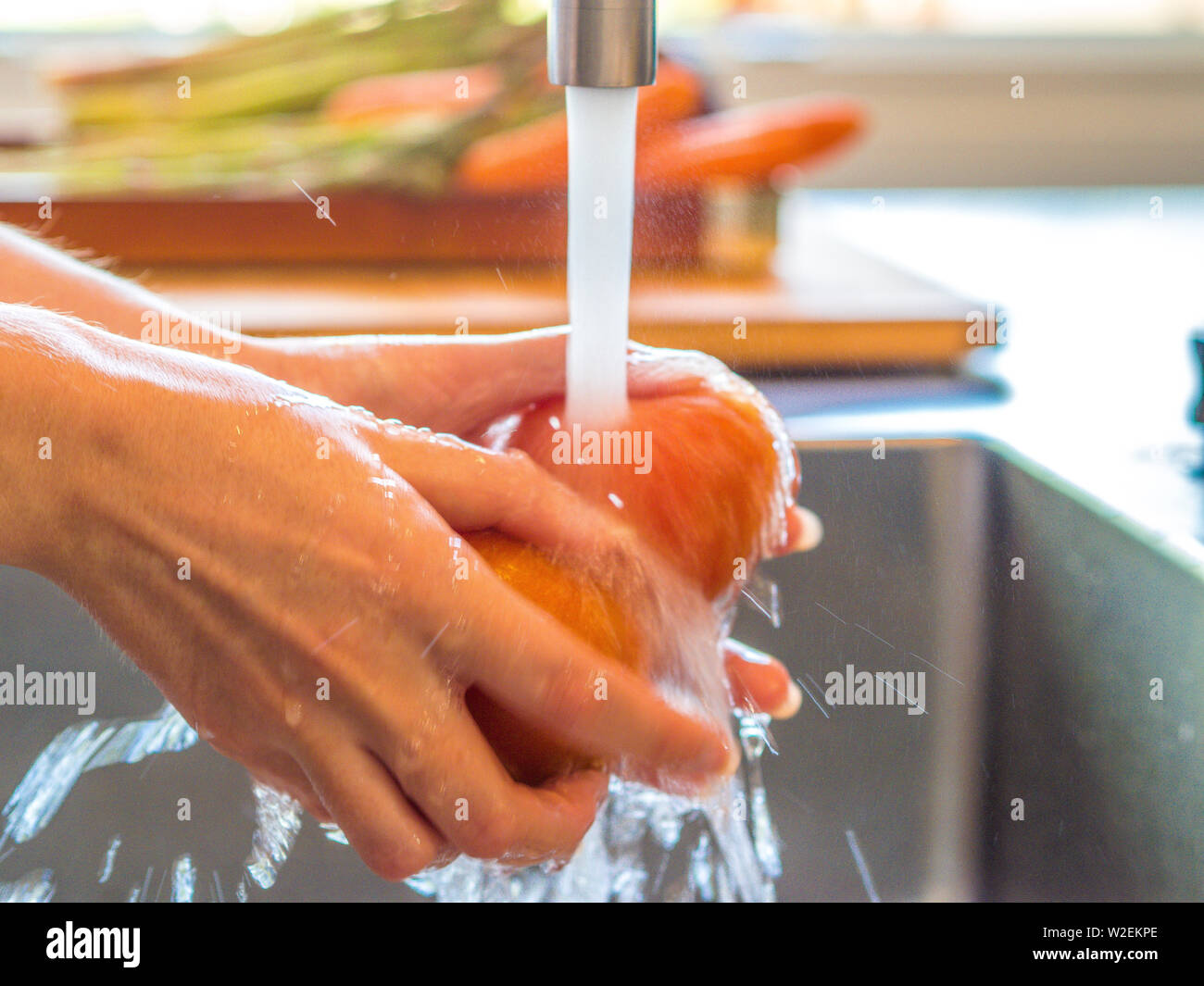 Caucasian girl's hands washing tomatoes under the tap water in her ...