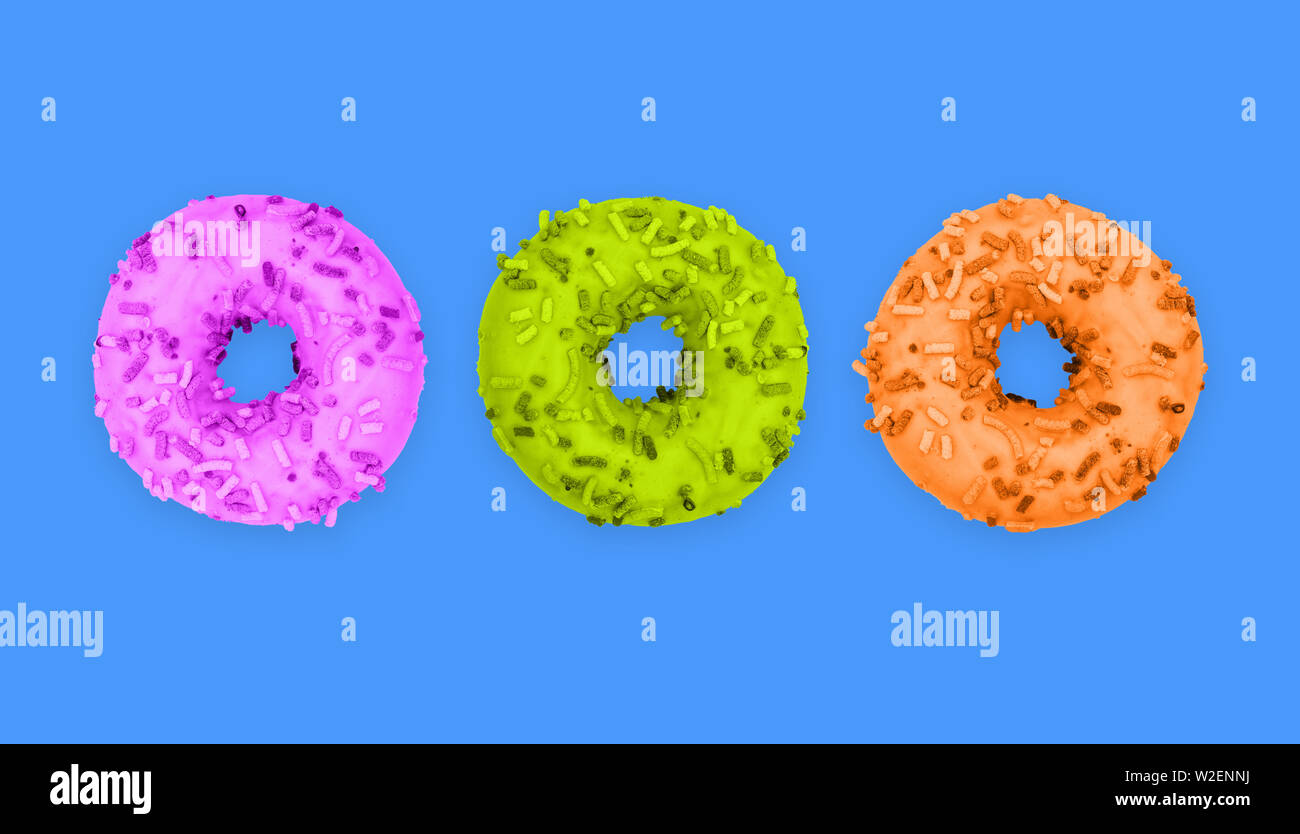 Three multi-colored donuts on a blue background. Sweet donuts in the ...