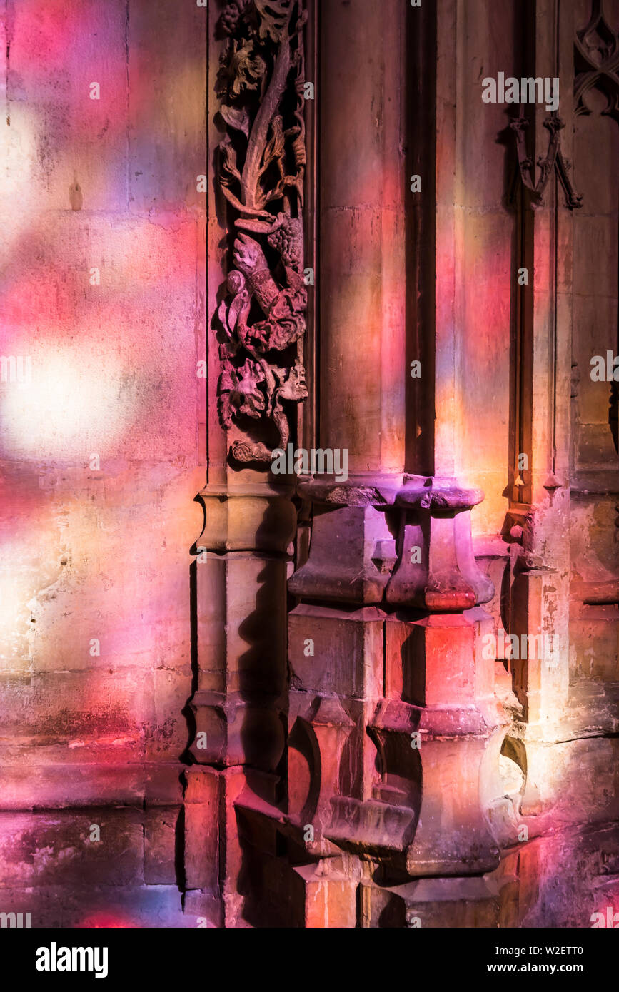 Colourful light filtered through a stained glass window on a wall in ...