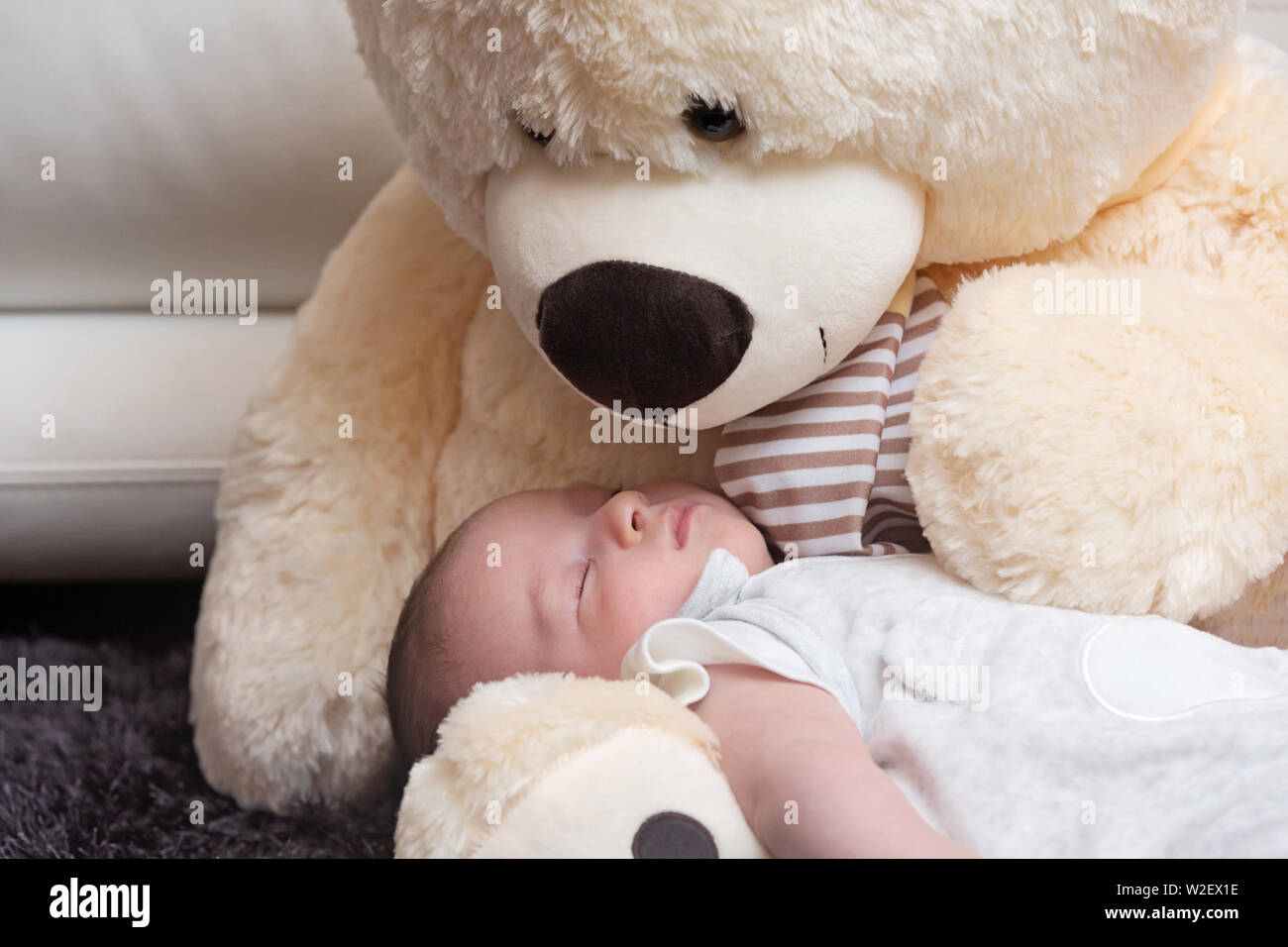 Peaceful newborn sleeping with giant fluffy teddy bear Stock Photo - Alamy