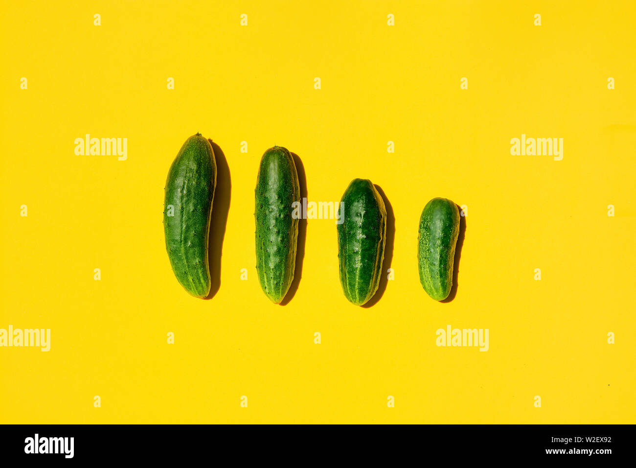 Concept Cucumbers Family on a yellow background. Dad mom baby ...