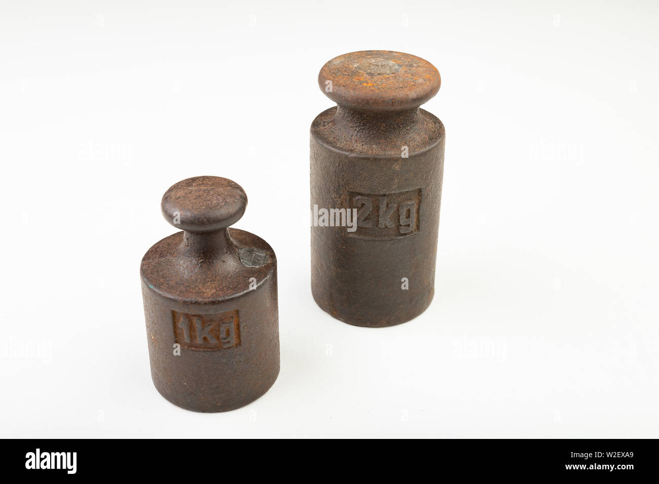 Old weights for weighing on a white table. Steel weights worth 1 and 2 ...