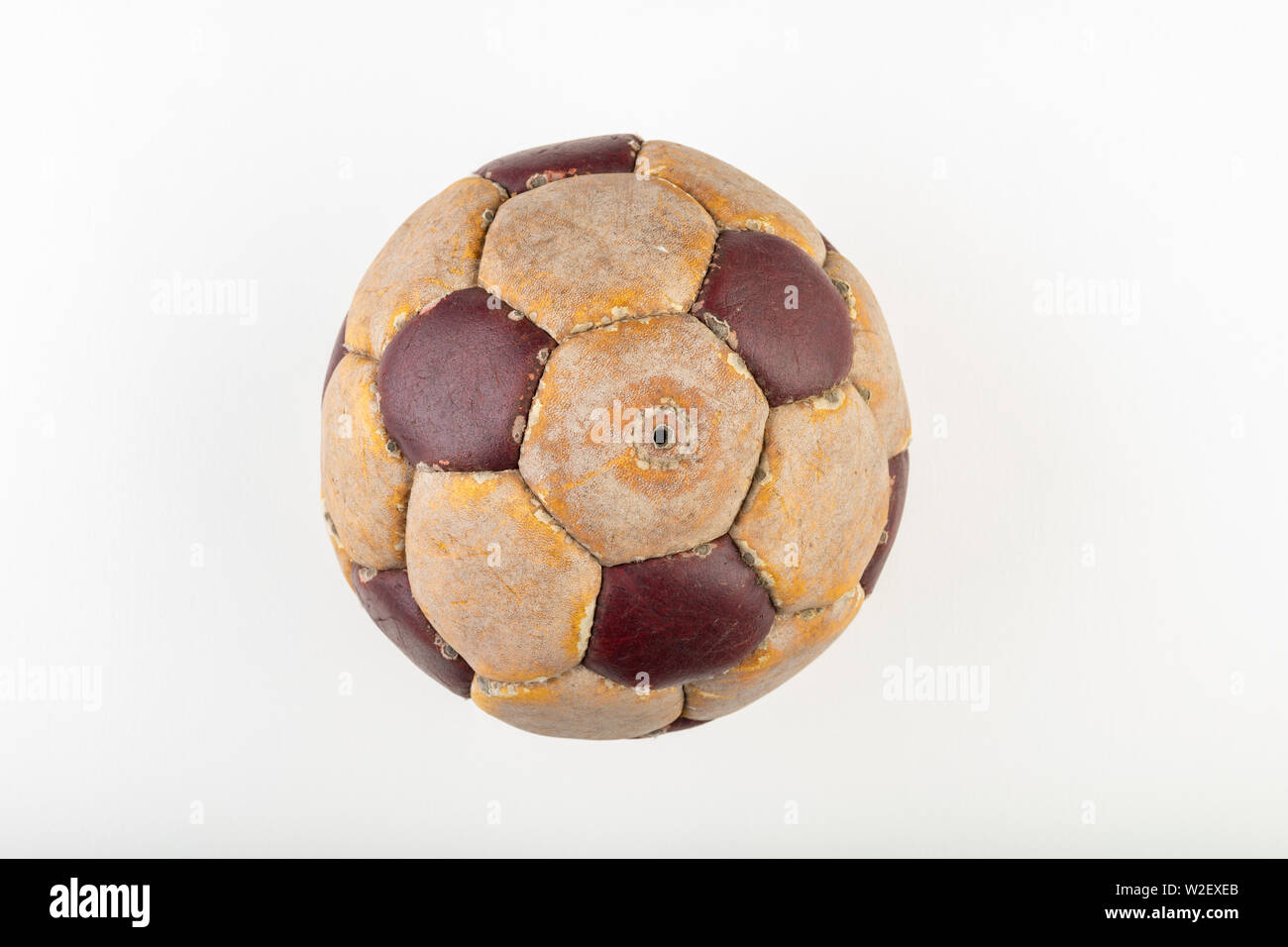 Old soccer ball to play on the leg on a white table. Leather and ...