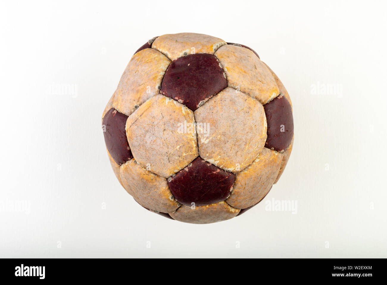 Old soccer ball to play on the leg on a white table. Leather and ...