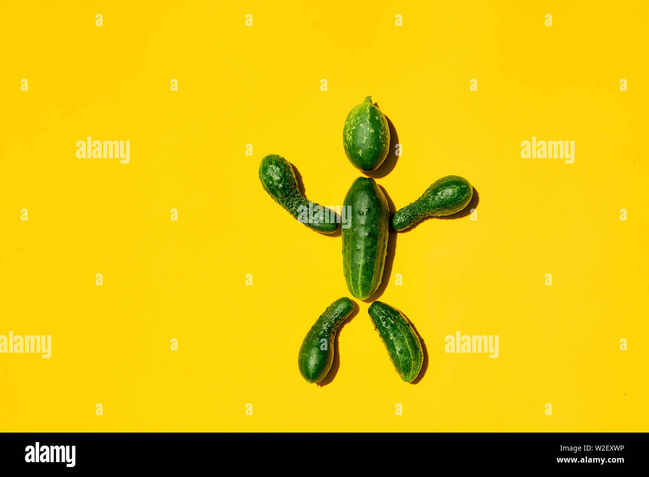 Cucumber man on a yellow background. Figure of man made from cucumbers ...