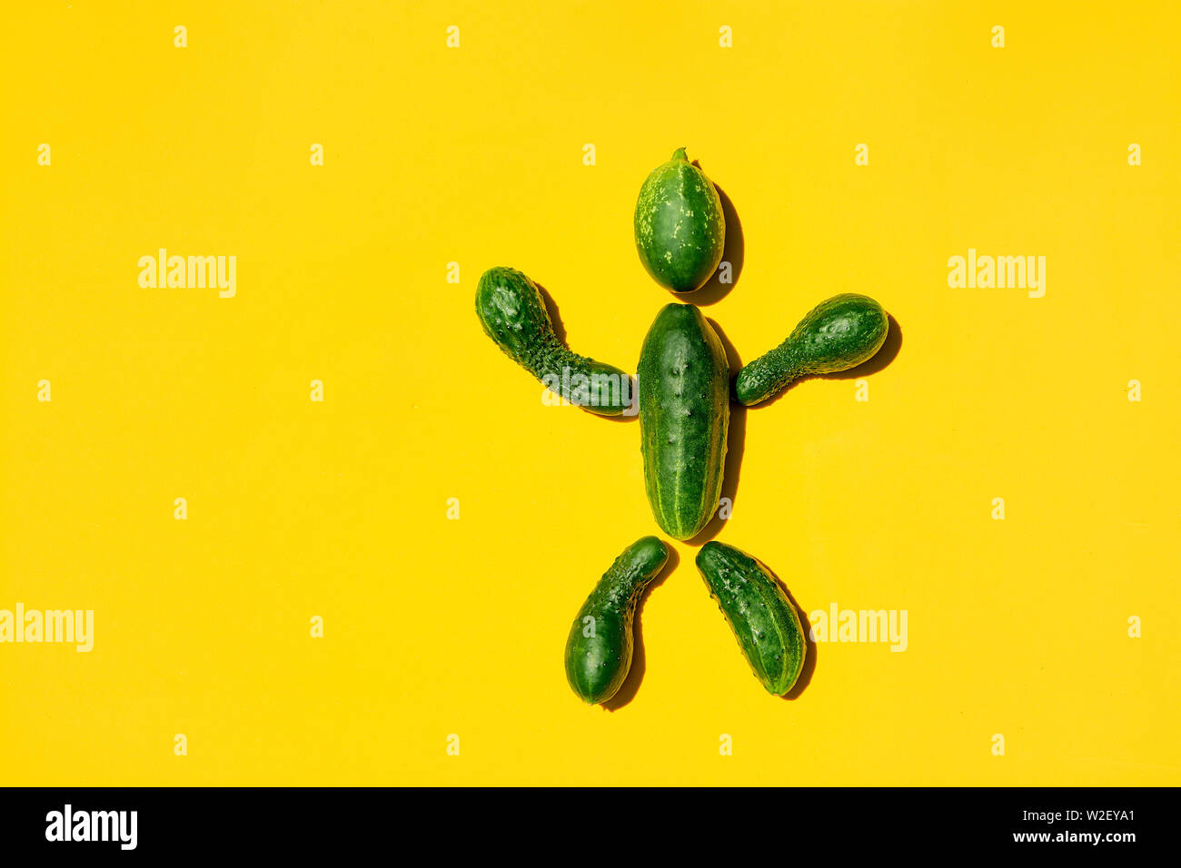 Cucumber man on a yellow background. Figure of man made from cucumbers ...