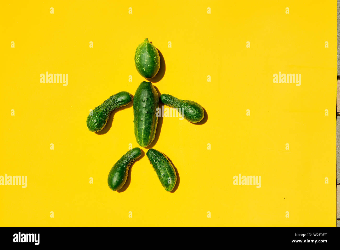 Cucumber man on a yellow background. Figure of man made from cucumbers ...