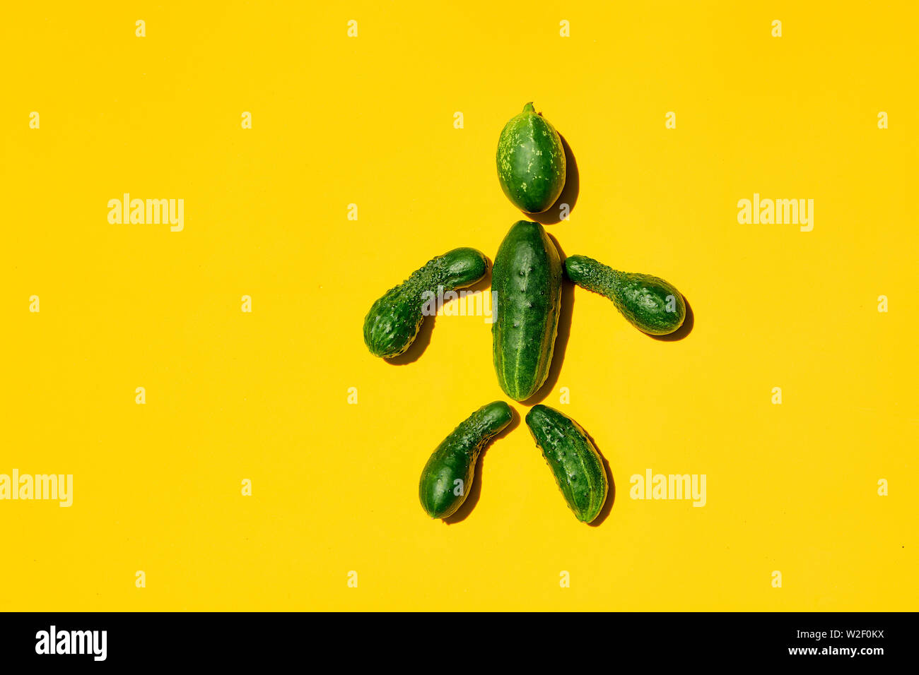 Cucumber man on a yellow background. Figure of man made from cucumbers ...