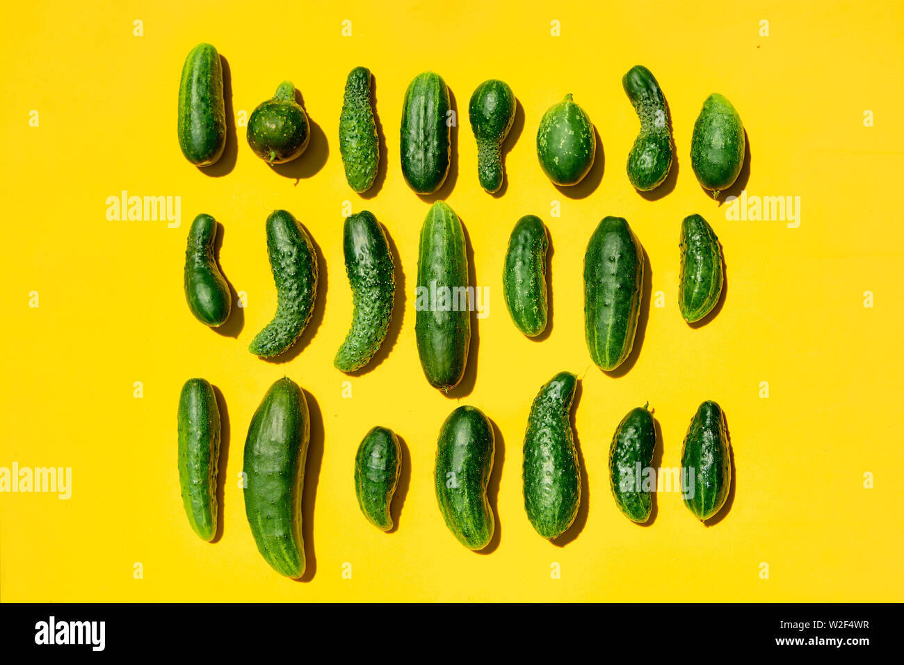Different sizes forms cucumbers pattern on a light yellow background ...