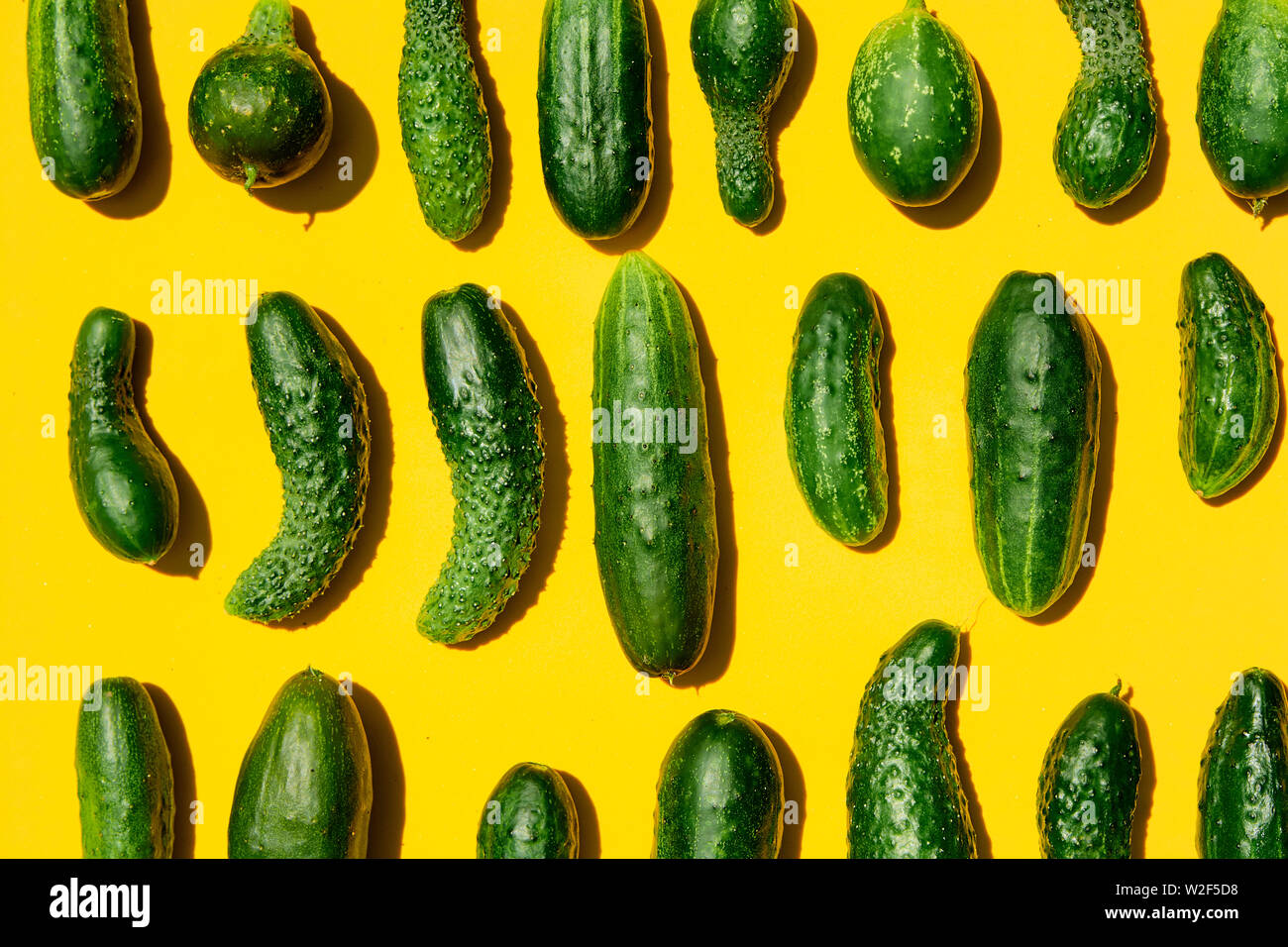 Different sizes forms cucumbers pattern on a light yellow background ...