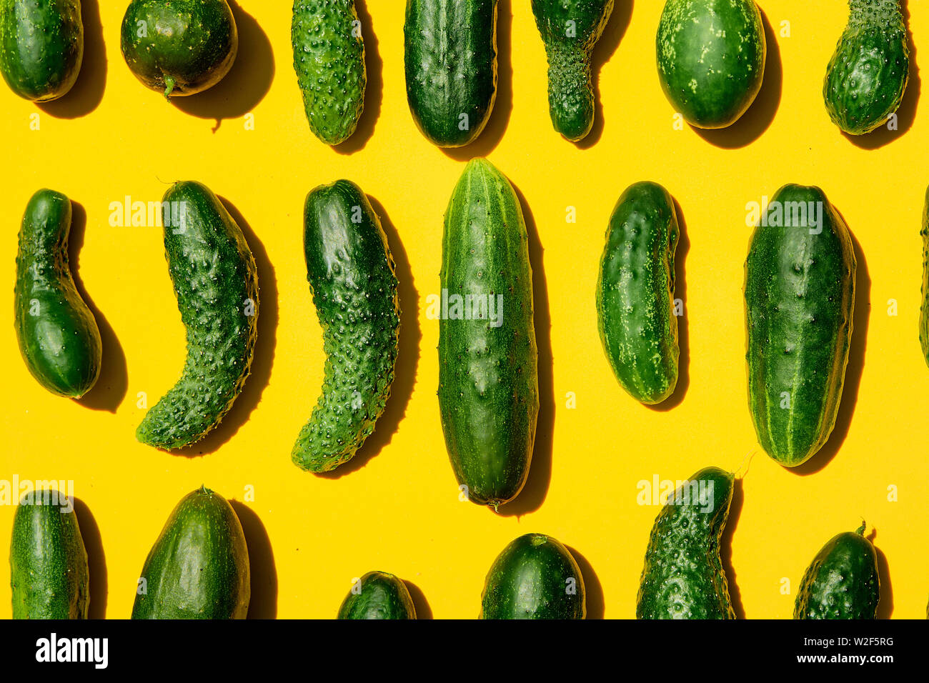 Different sizes forms cucumbers pattern on a light yellow background ...