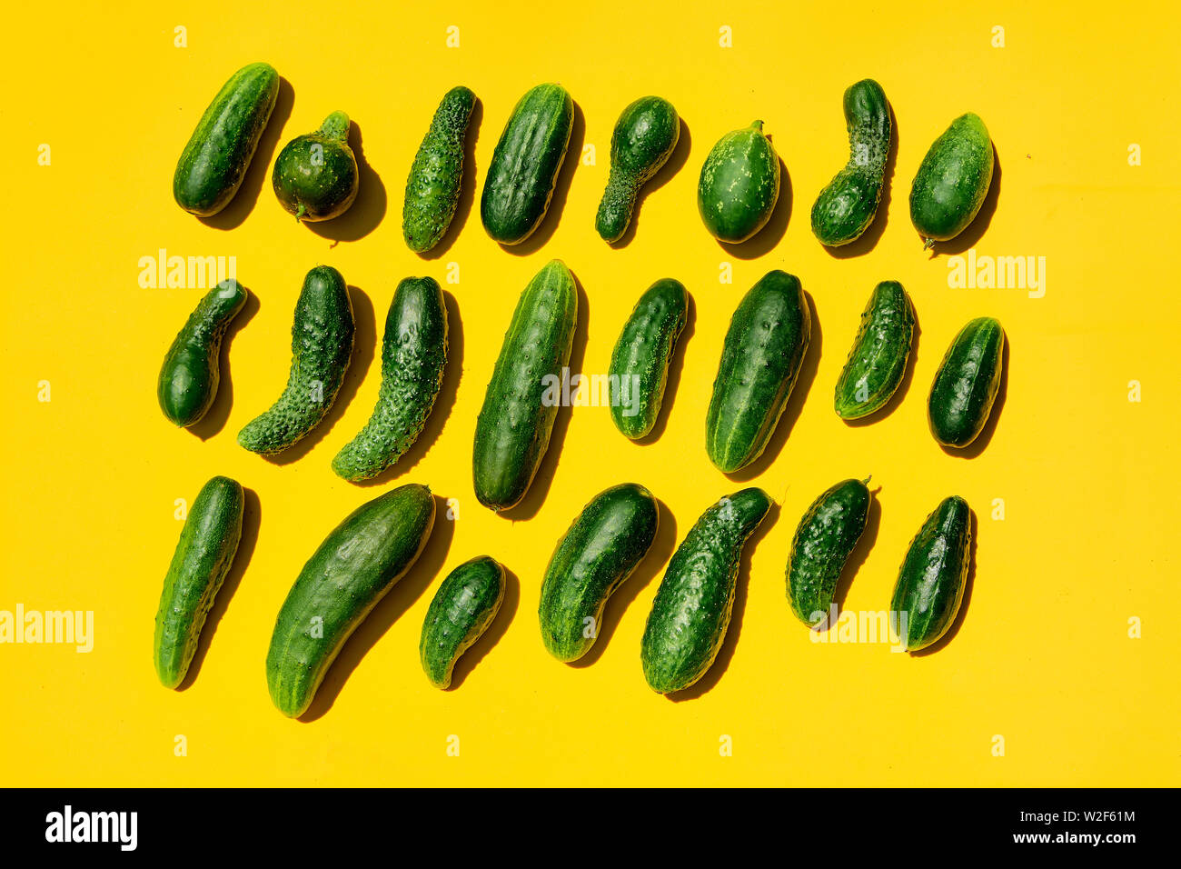 Different sizes forms cucumbers pattern on a light yellow background ...
