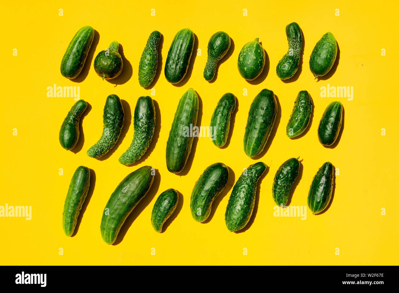 Different sizes forms cucumbers pattern on a light yellow background ...