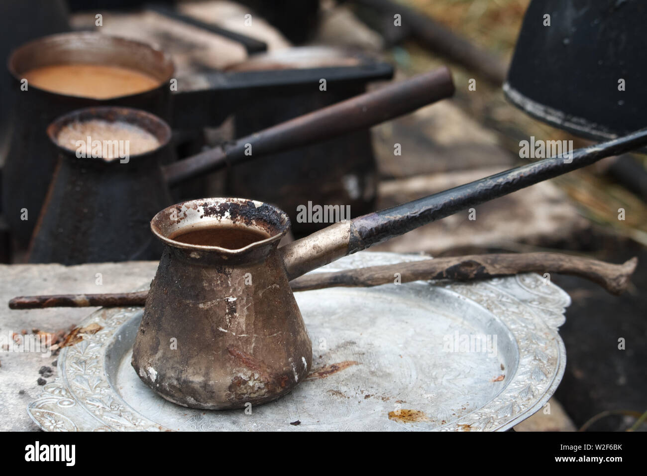Boiling coffee in turkish cezva on a grate over a burning bonfire ...