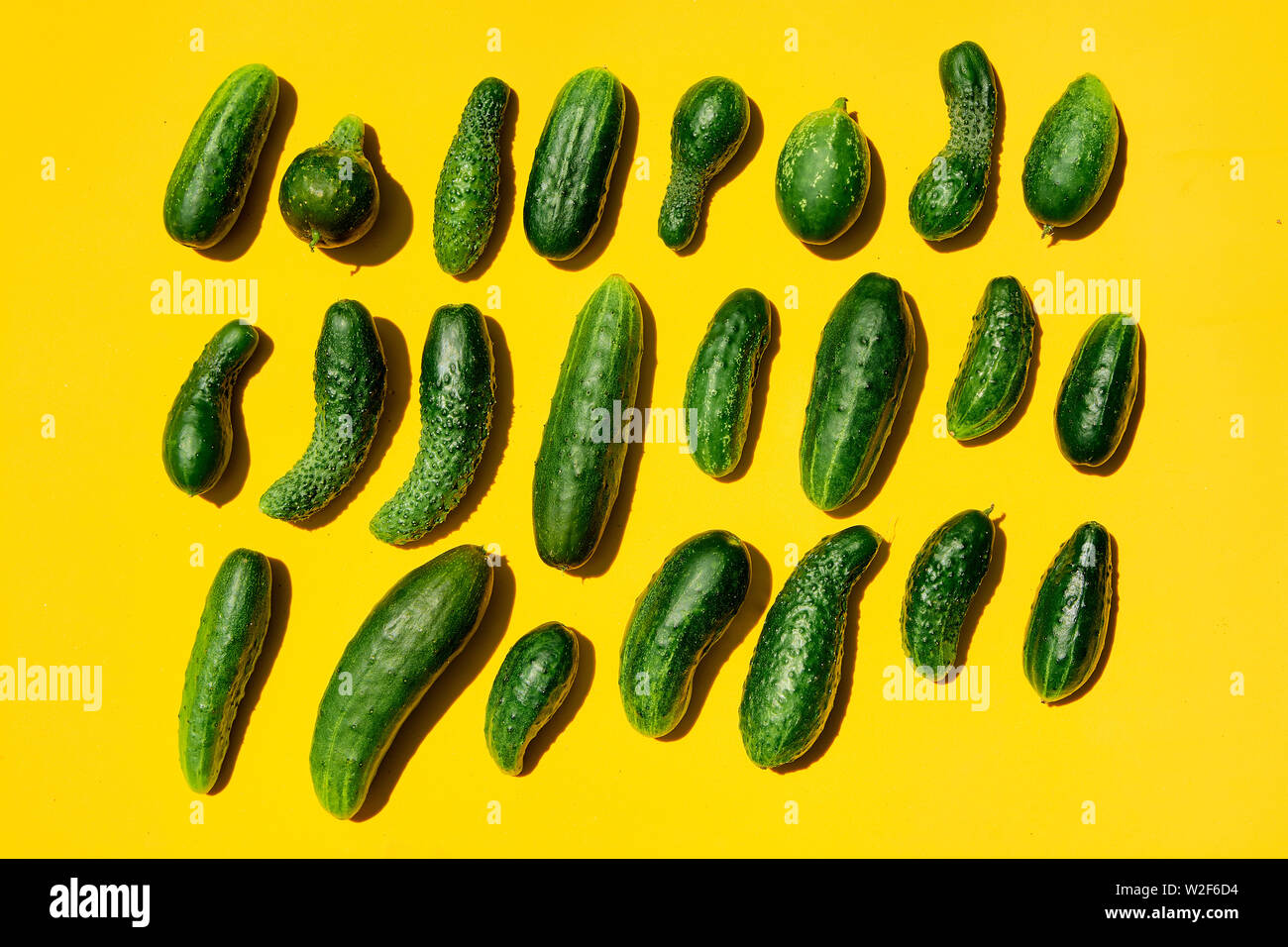 Different sizes forms cucumbers pattern on a light yellow background ...
