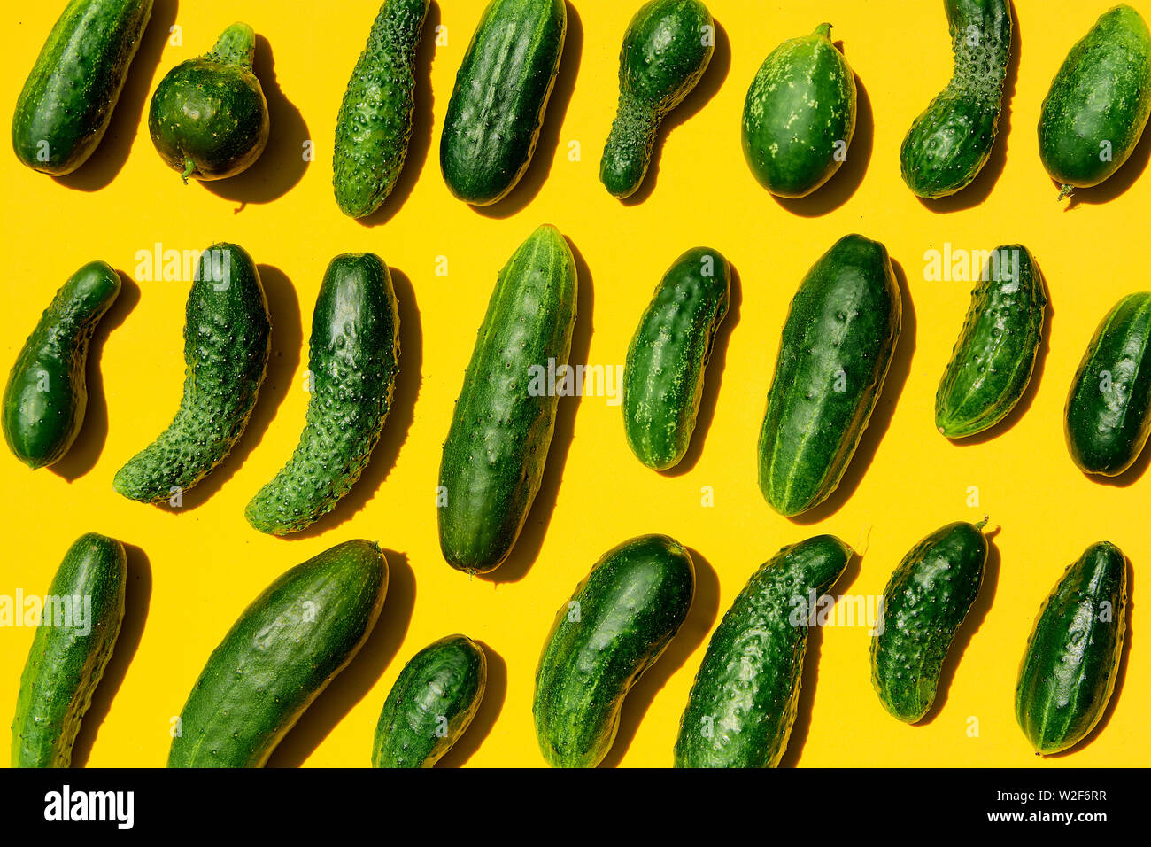 Different sizes forms cucumbers pattern on a light yellow background ...