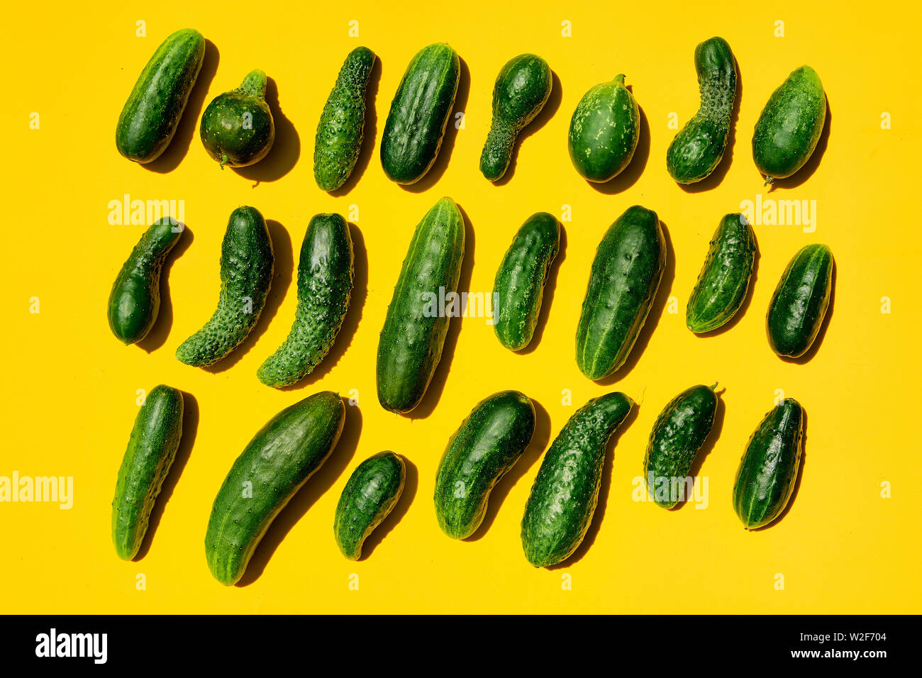 Different sizes forms cucumbers pattern on a light yellow background ...