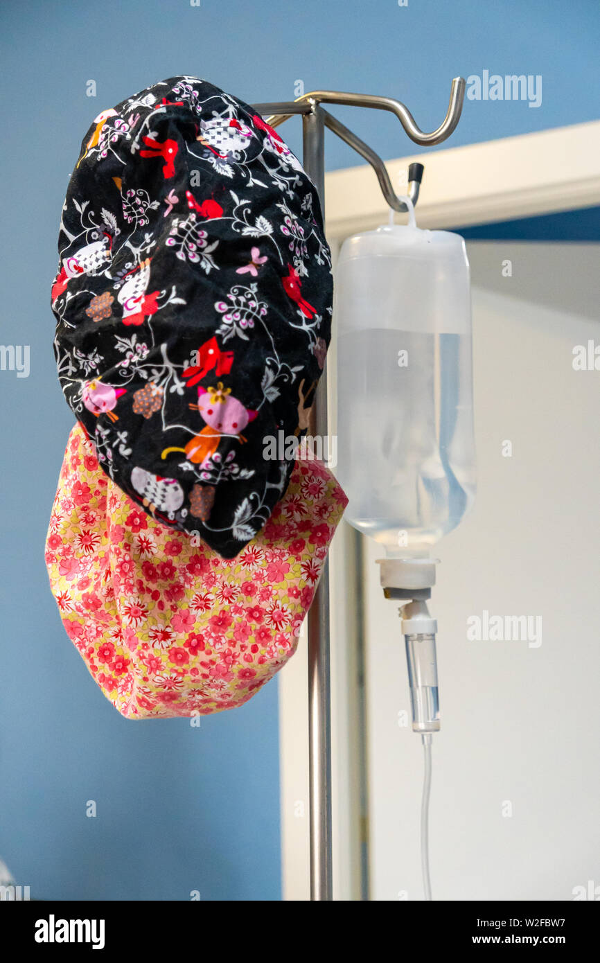 Saline drip support with colorful surgical cap in a veterinary ...