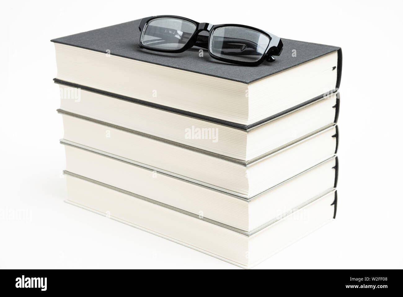 A neatly stacked set of five monochromatic cloth-bound books with ...