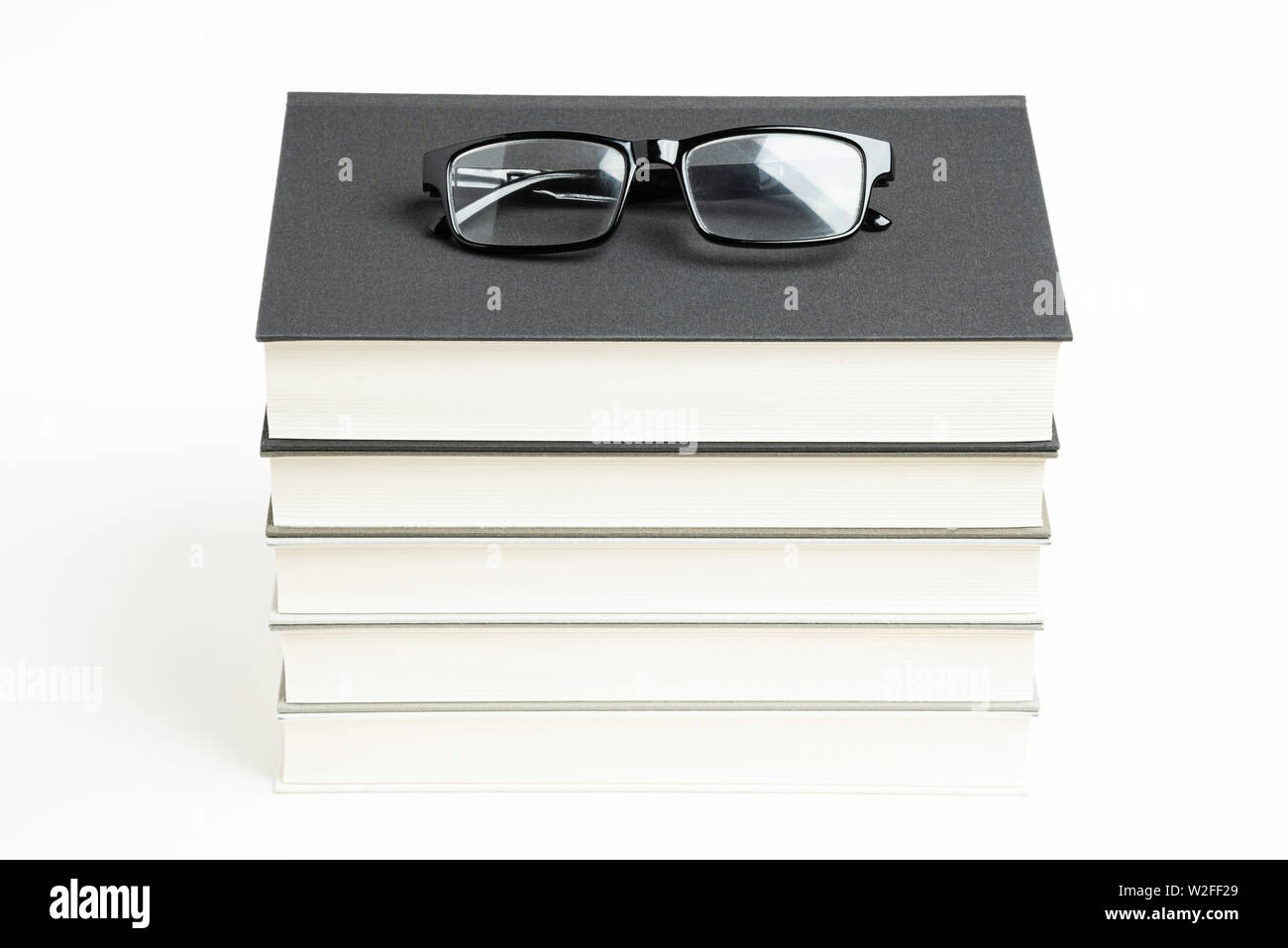 A neatly stacked set of five monochromatic cloth-bound books with ...