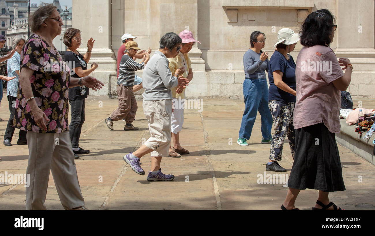 Mainly older people exercising the ancient Chinese slow moving exercise ...