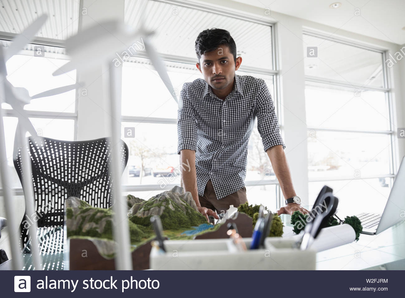 Portrait confident male engineer with wind turbine model Stock Photo ...
