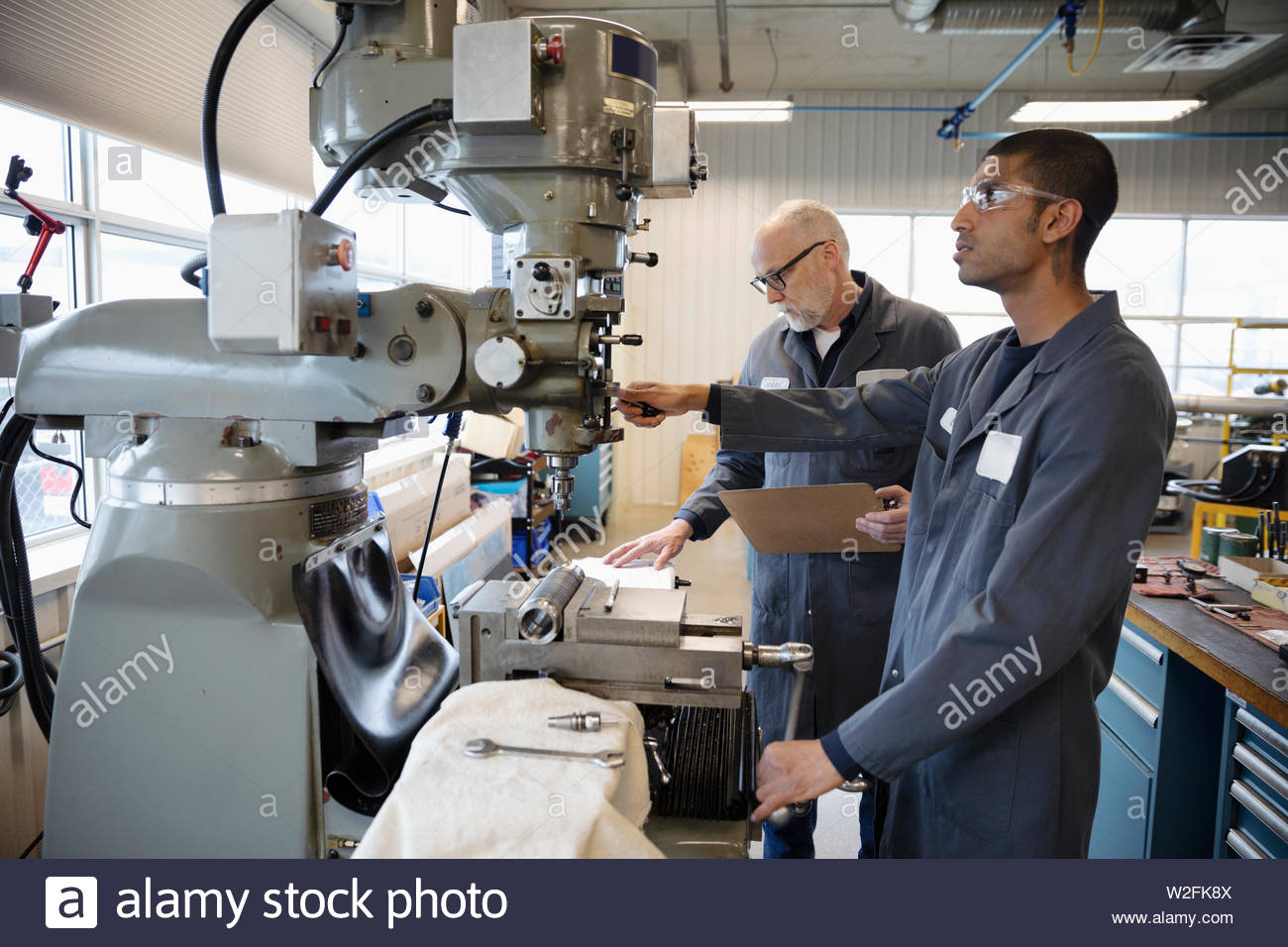 Machinists using equipment in factory Stock Photo - Alamy