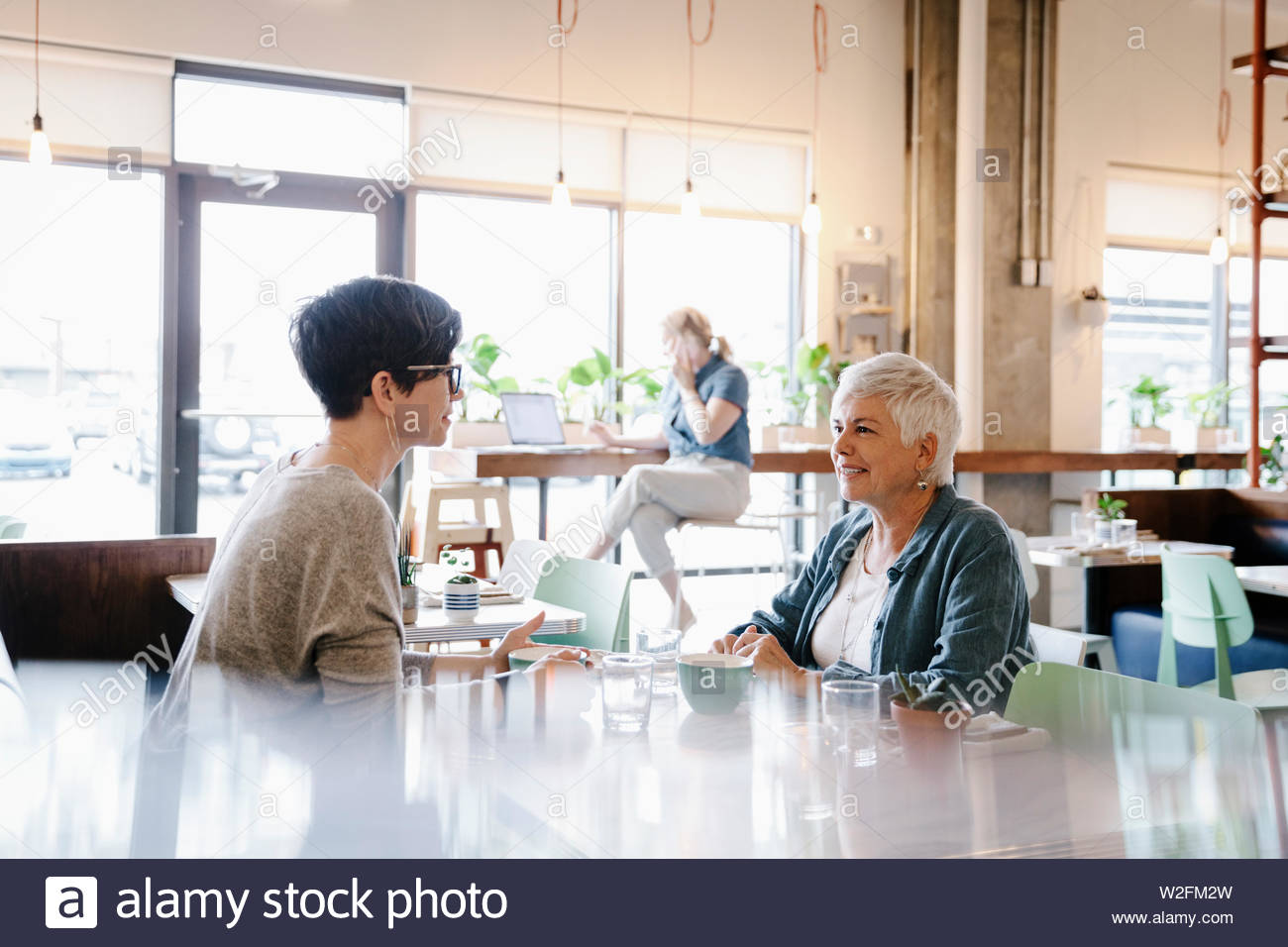 Two women talking in cafe side view hi-res stock photography and images ...