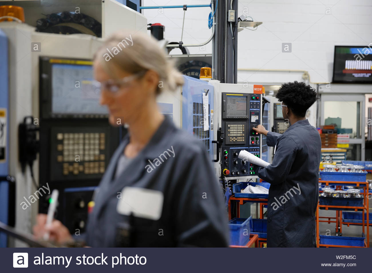 Machinists operating machinery in factory Stock Photo - Alamy