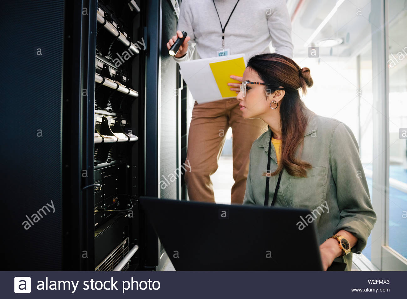 IT technicians examining equipment in network server room Stock Photo ...
