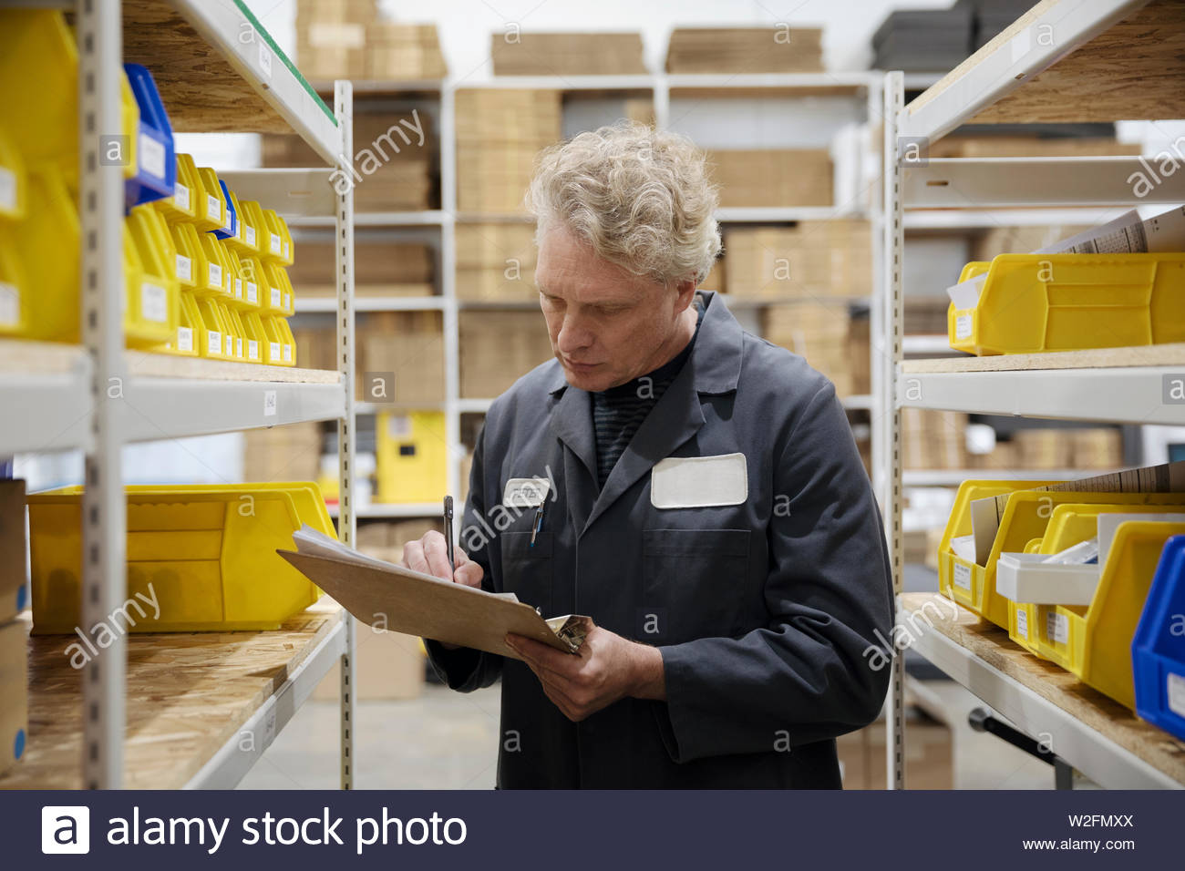 Male worker checking inventory in warehouse Stock Photo - Alamy