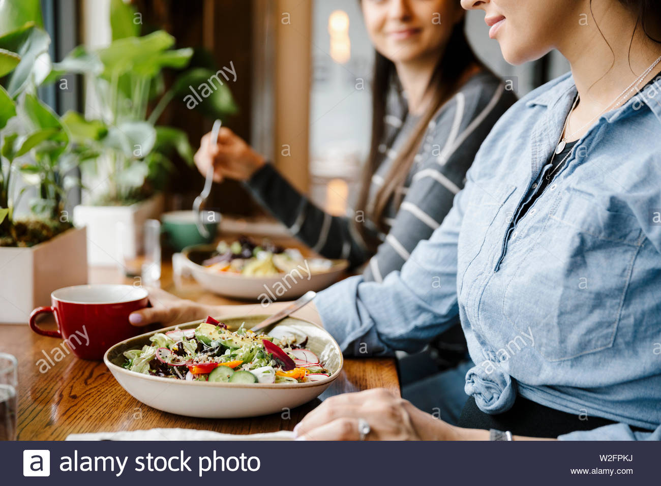 Two women eating in restaurant hi-res stock photography and images - Alamy