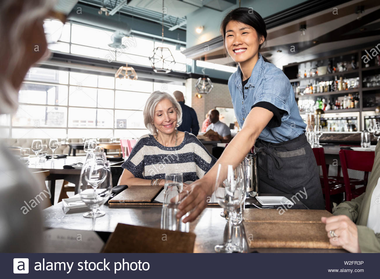 Friendly waitress serving senior women friends in restaurant Stock ...