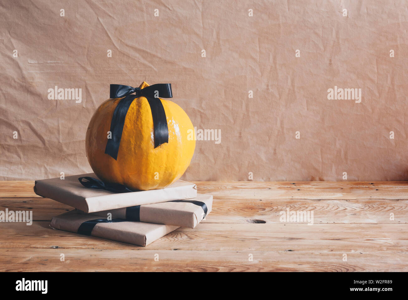 Halloween gift box with ribbons and pumpkins on wooden table. Holiday ...