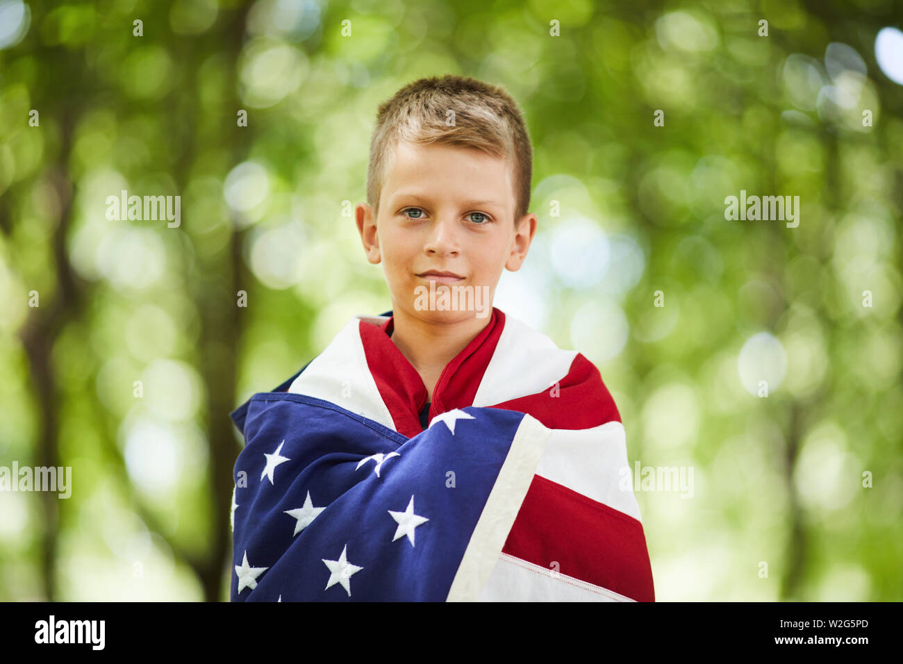 Portrait of serious confident boy proud of his country wrapped in ...